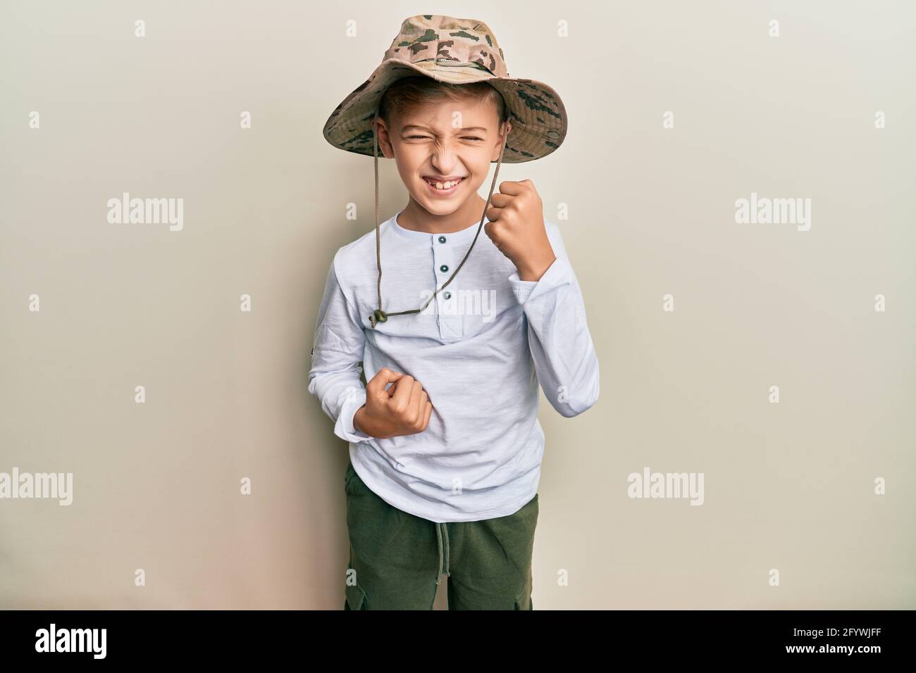 Little caucasian boy kid wearing explorer hat celebrating surprised and ...