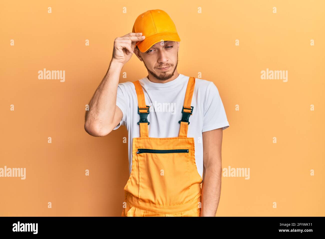 Hispanic young man wearing handyman uniform worried and stressed about ...