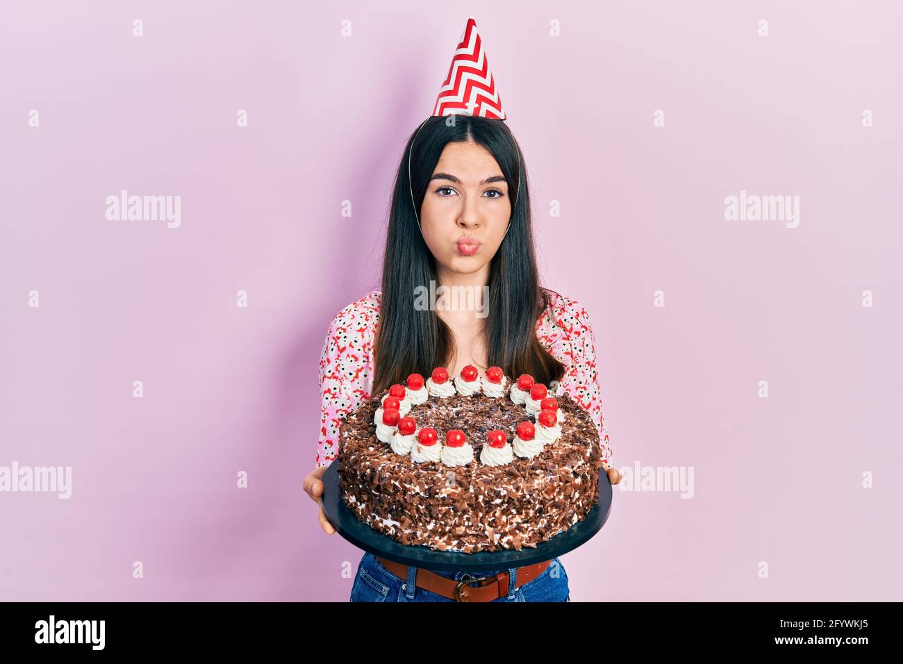 Young brunette woman celebrating birthday holding big chocolate cake ...