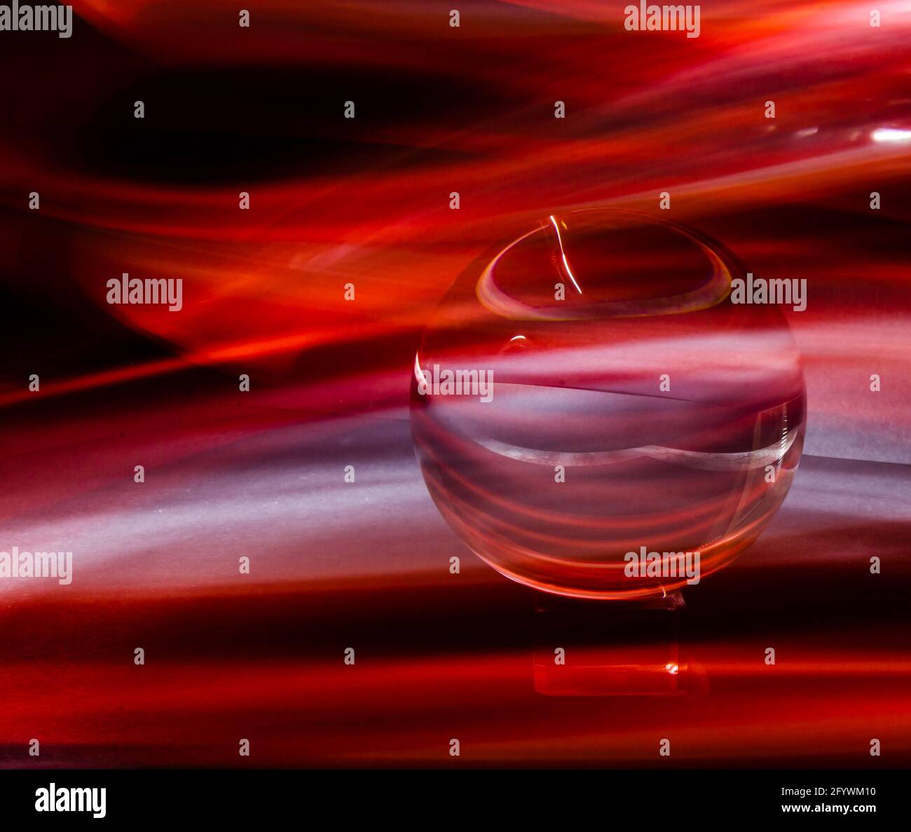 an illustration of a round crystal ball with red smoke waves on black ...