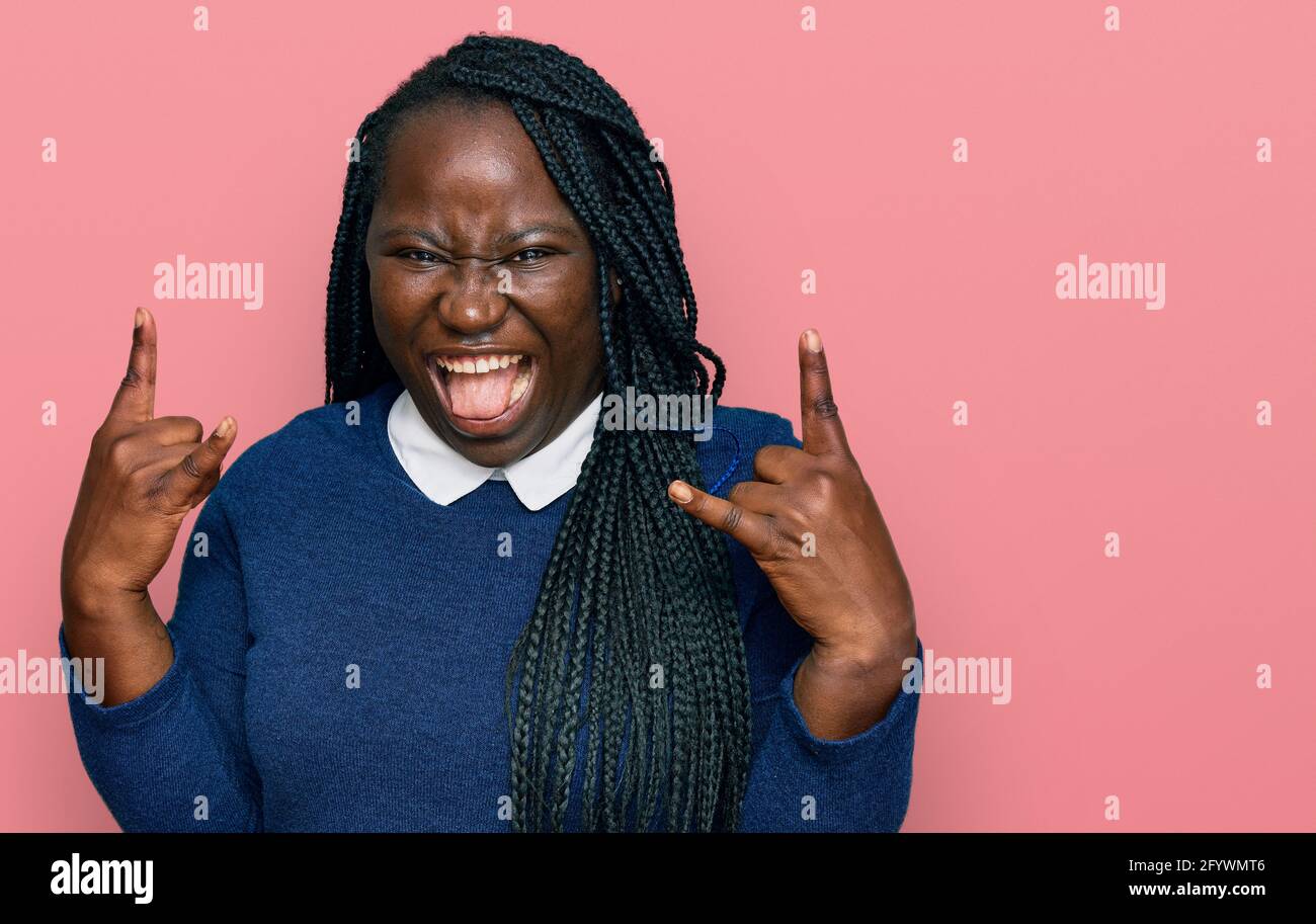 Young black woman with braids wearing casual clothes shouting with ...