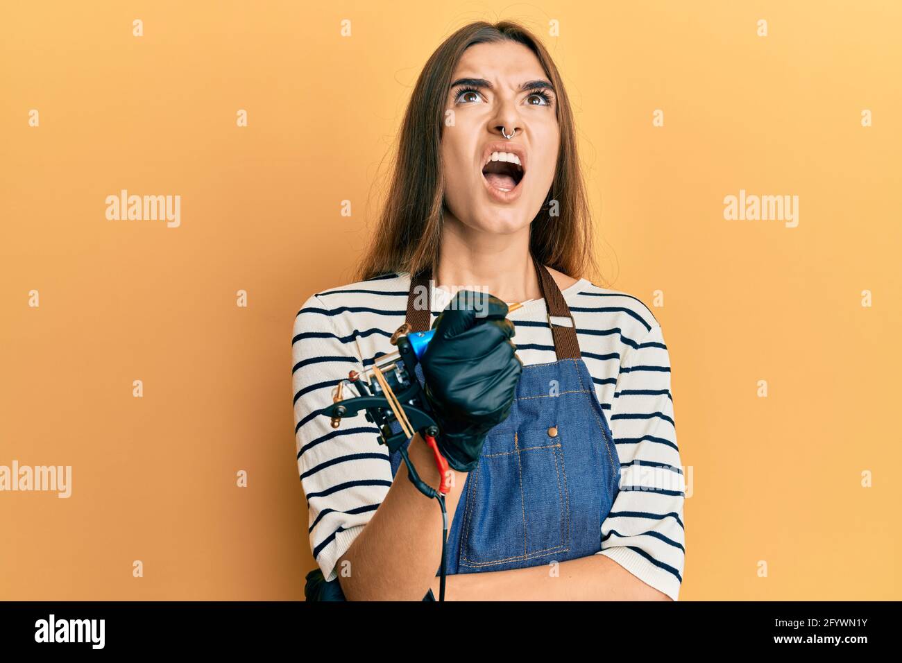 Young hispanic woman tattoo artist wearing professional uniform and ...