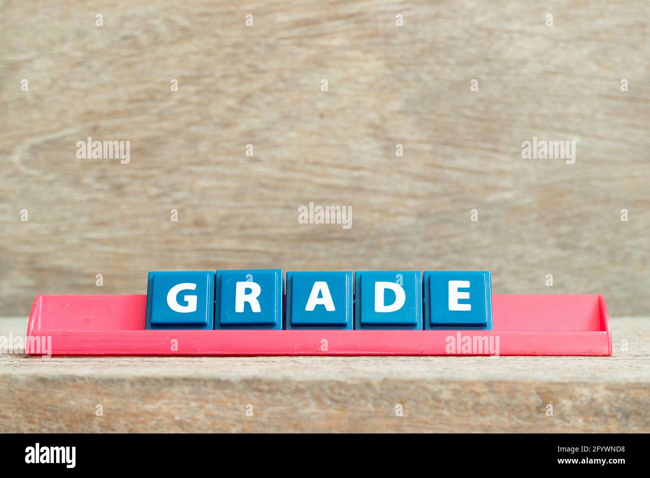 Tile alphabet letter with word grade in red color rack on wood ...
