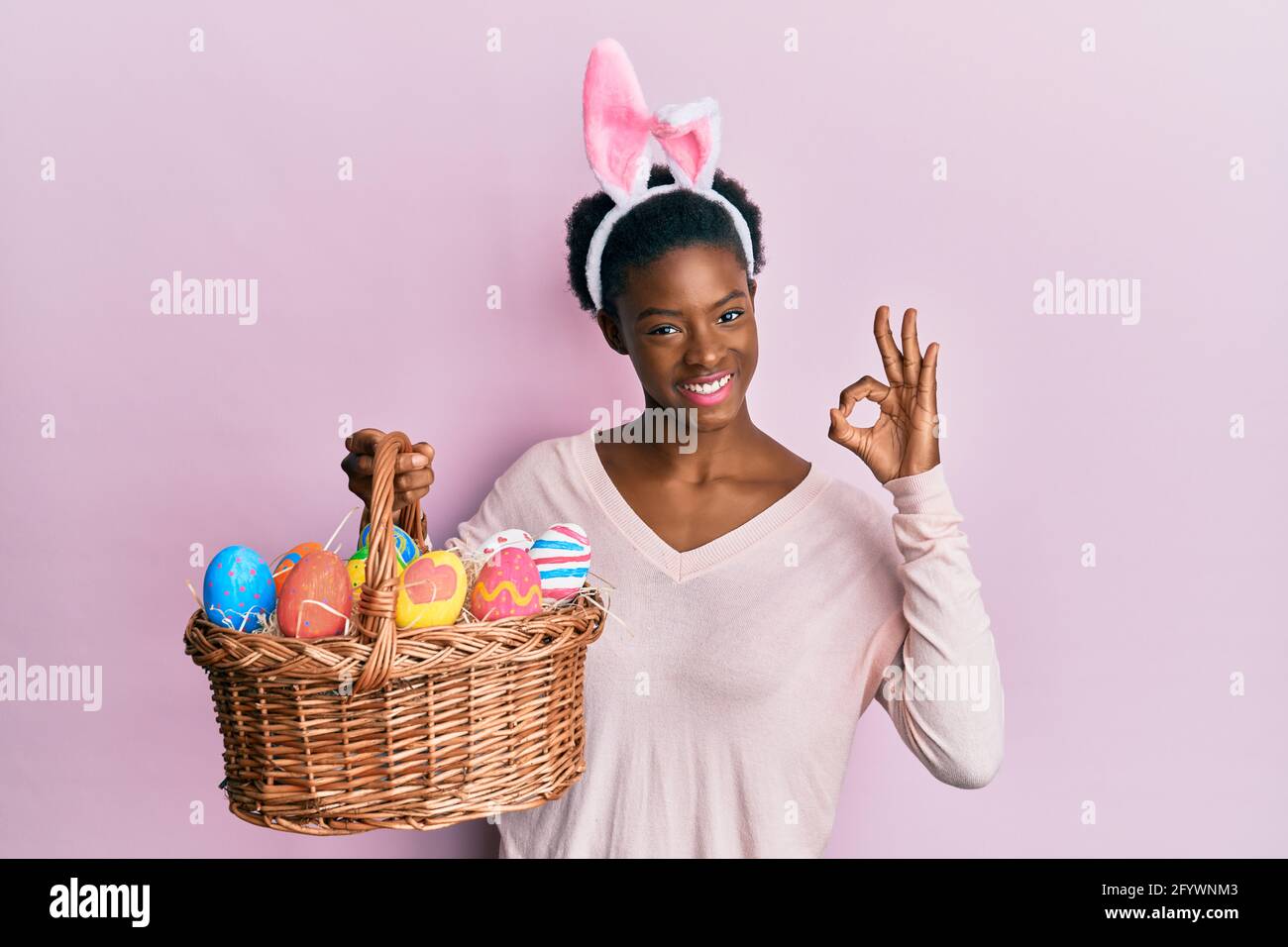 Young african american girl wearing cute easter bunny ears holding ...
