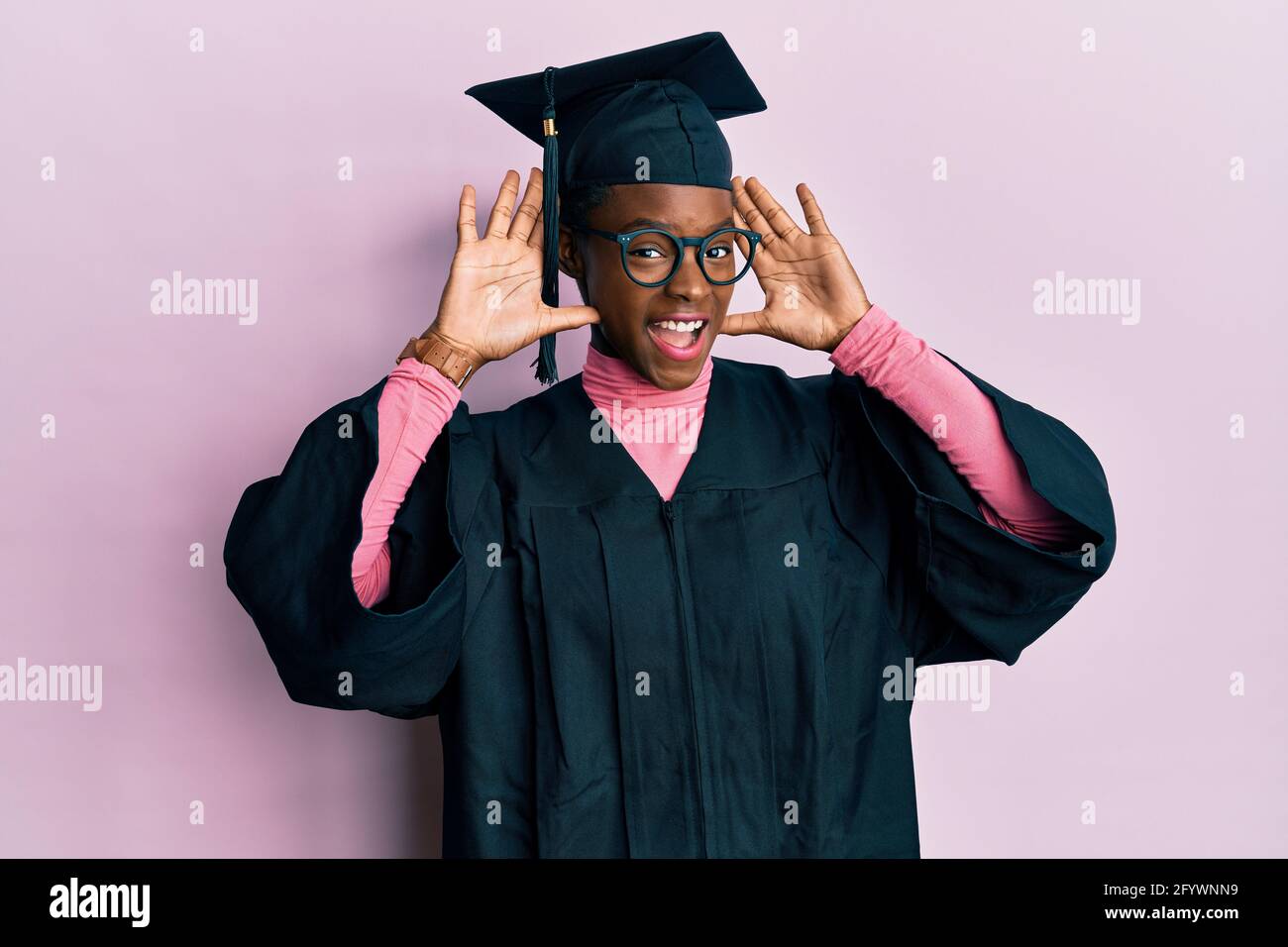 Young african american girl wearing graduation cap and ceremony robe ...