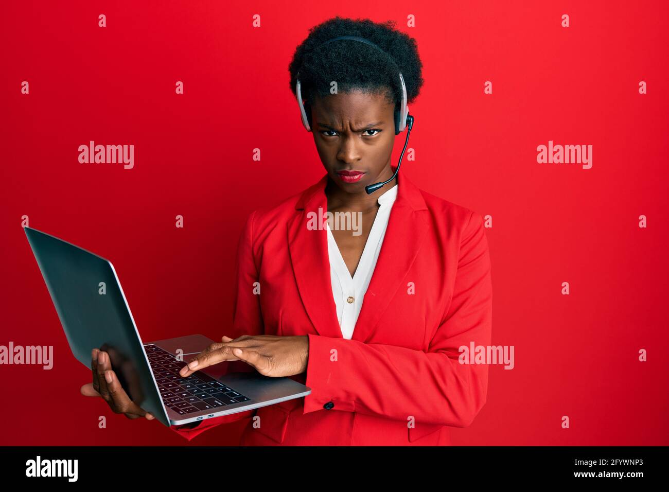 Young african american girl working at the office wearing operator ...