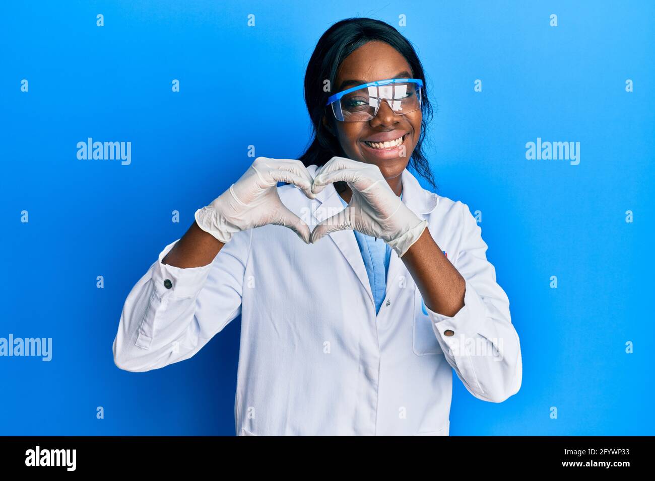 Young african american woman wearing scientist uniform smiling in love ...