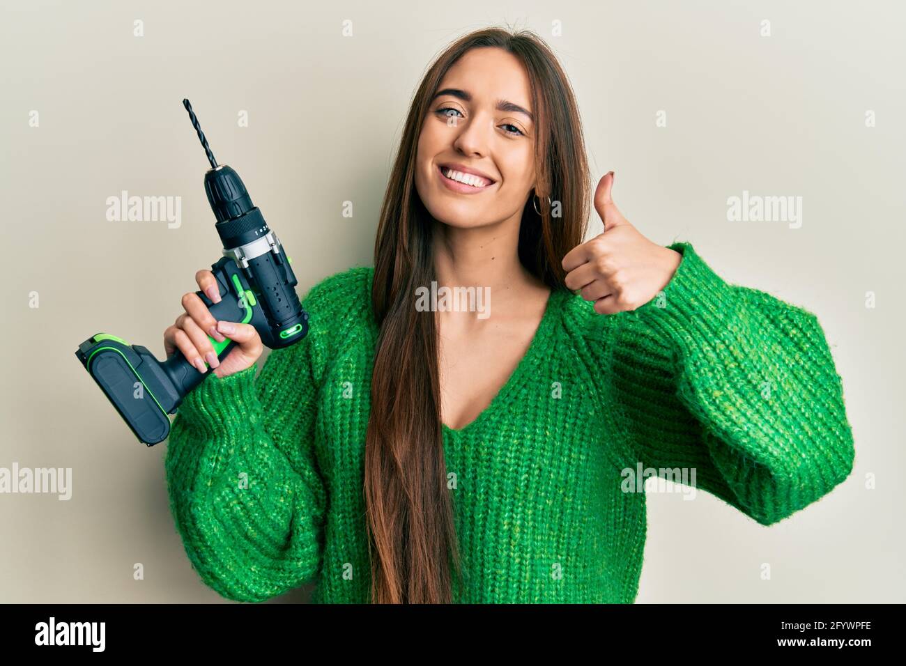 Young hispanic girl holding screwdriver smiling happy and positive ...