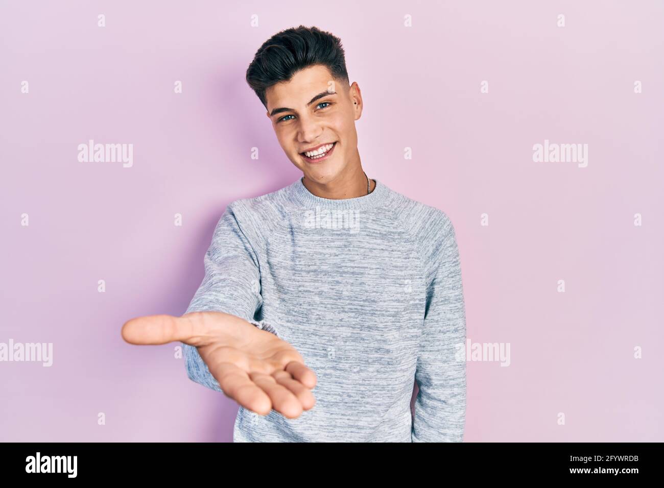Young hispanic man wearing casual clothes smiling friendly offering ...