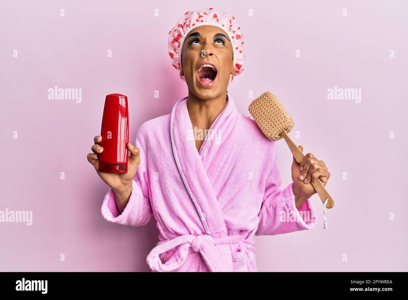 Hispanic man wearing make up wearing shower cap holding sponge and ...
