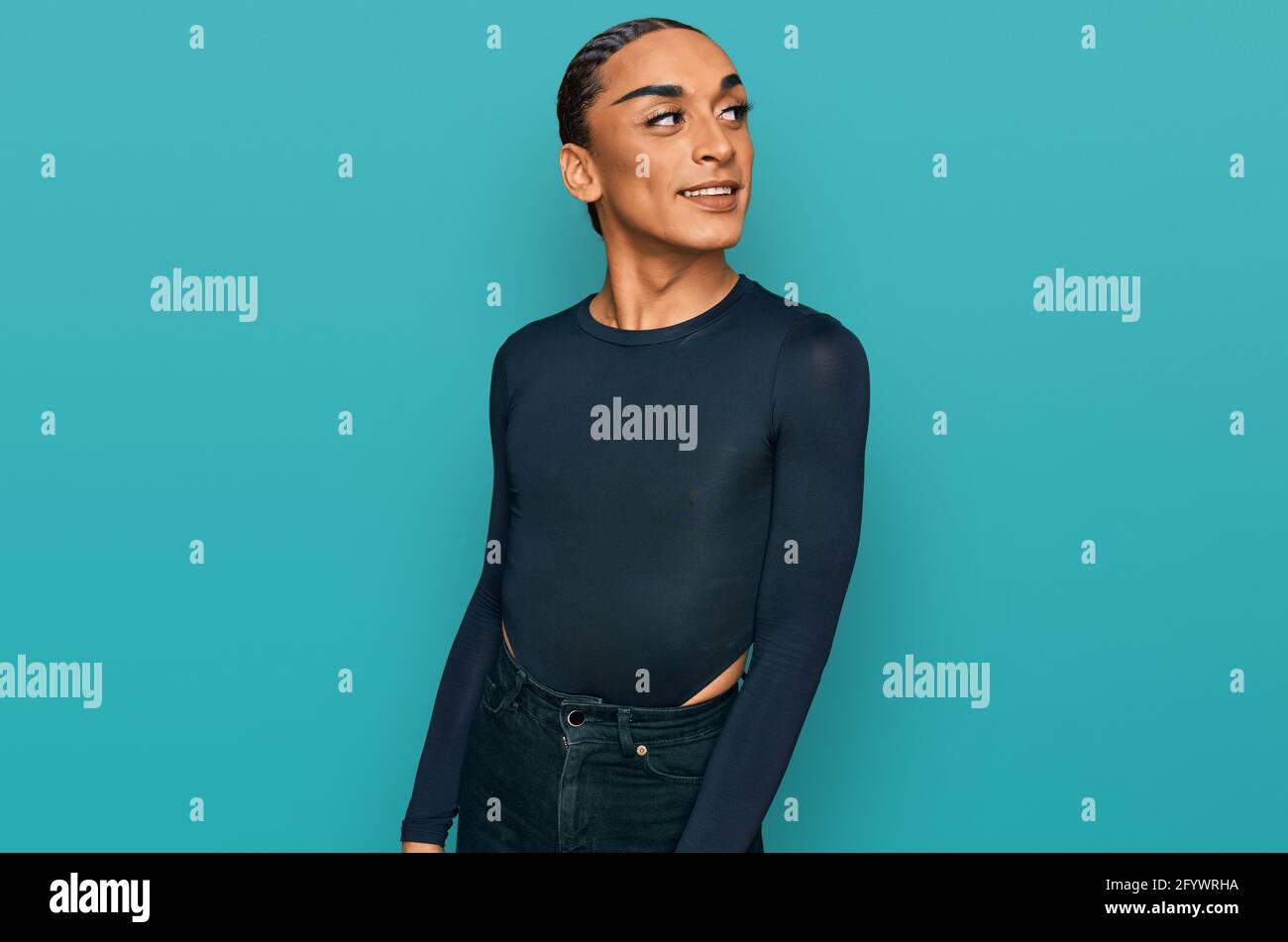 Hispanic transgender man wearing make up and long hair wearing casual clothes looking away to ...