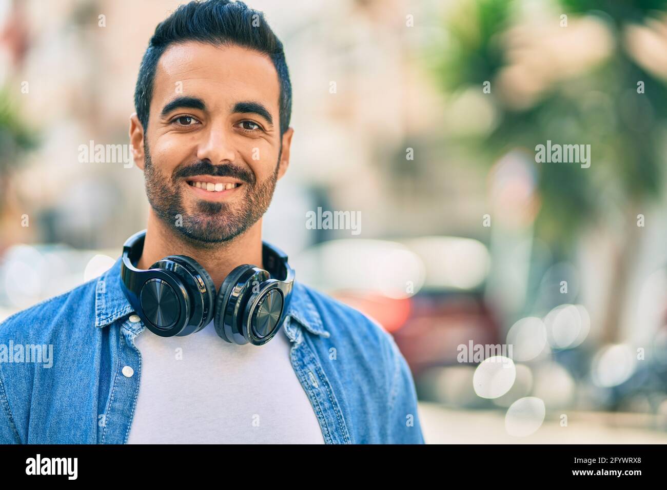 Young hispanic man smiling happy using headphones at the city Stock ...