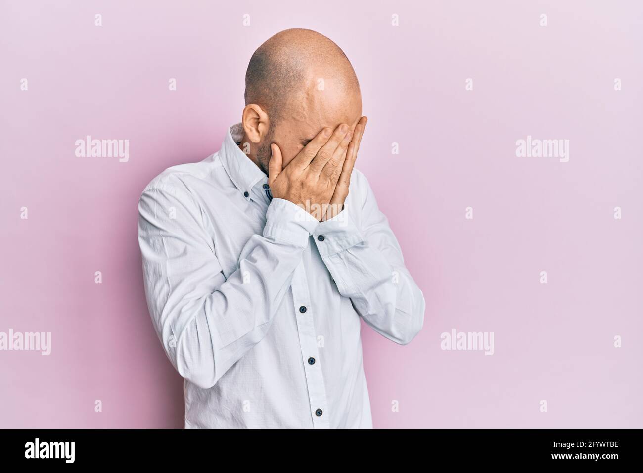 Young hispanic man wearing casual clothes with sad expression covering ...
