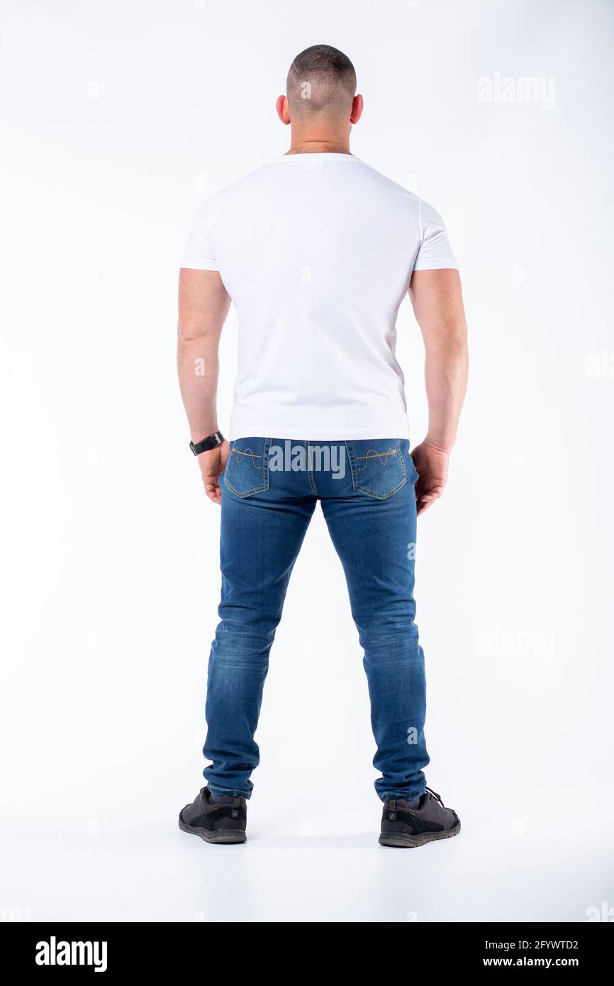 Rear view of a man standing, wearing a white t-shirt and a pair of ...