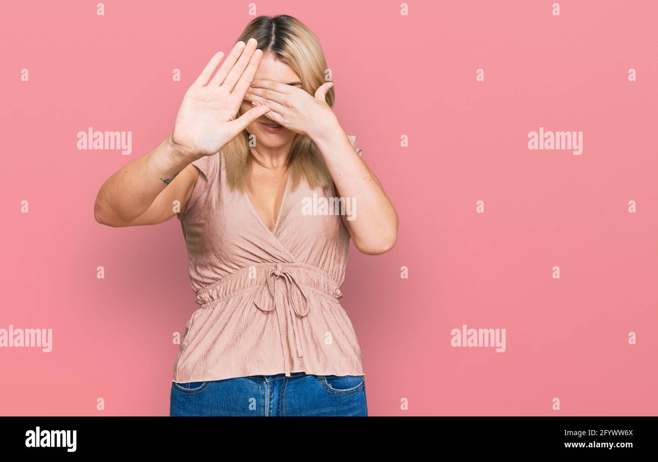 Young caucasian woman wearing casual clothes covering eyes with hands ...