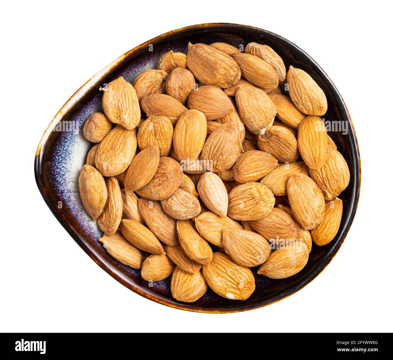 top view of raw apricot kernels in ceramic bowl isolated on white ...