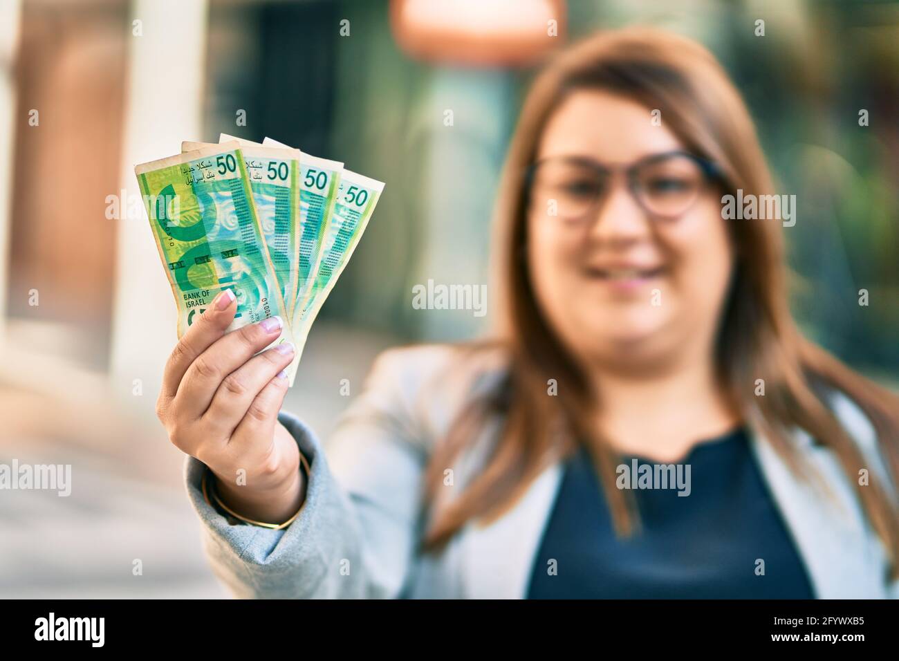 Young hispanic plus size businesswoman smiling happy holding israel ...