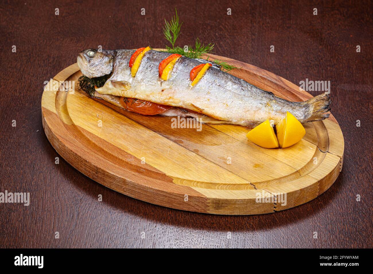 Baked trout staffed vegetables and served lemon Stock Photo - Alamy