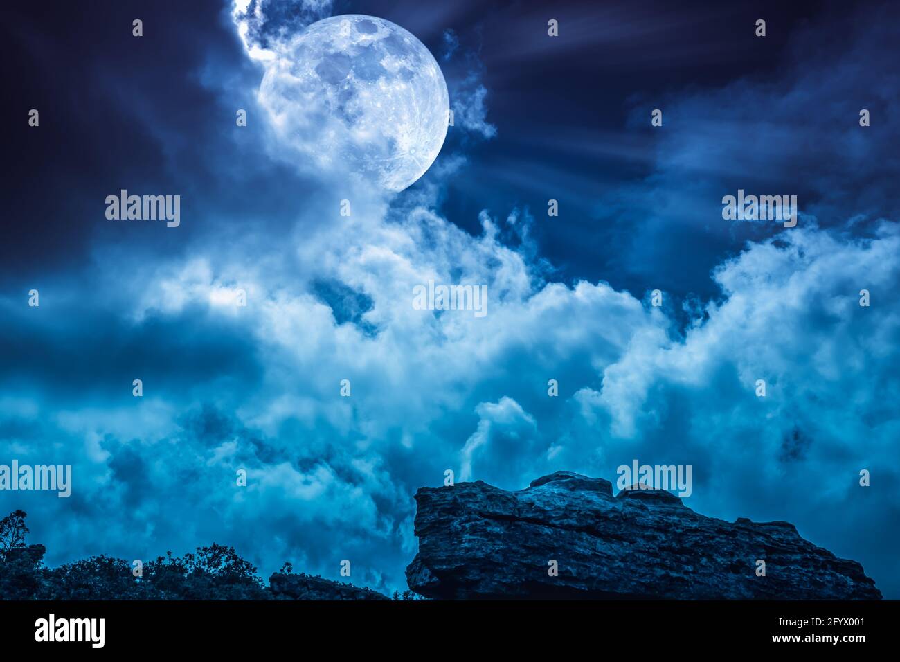 Boulder with blue sky background and beautiful full moon behind cloud ...