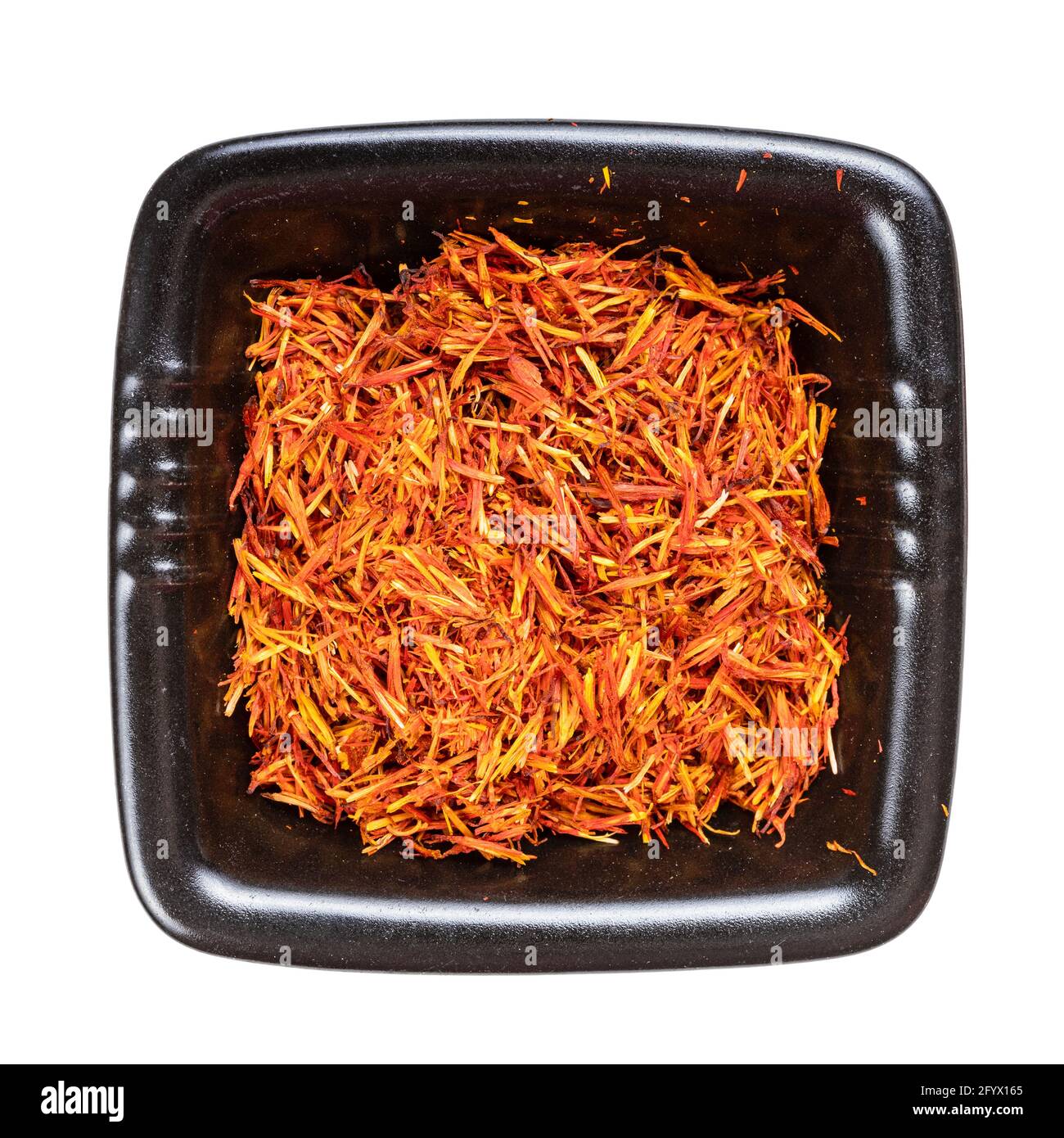 top view of dried safflower petals in black bowl isolated on white ...