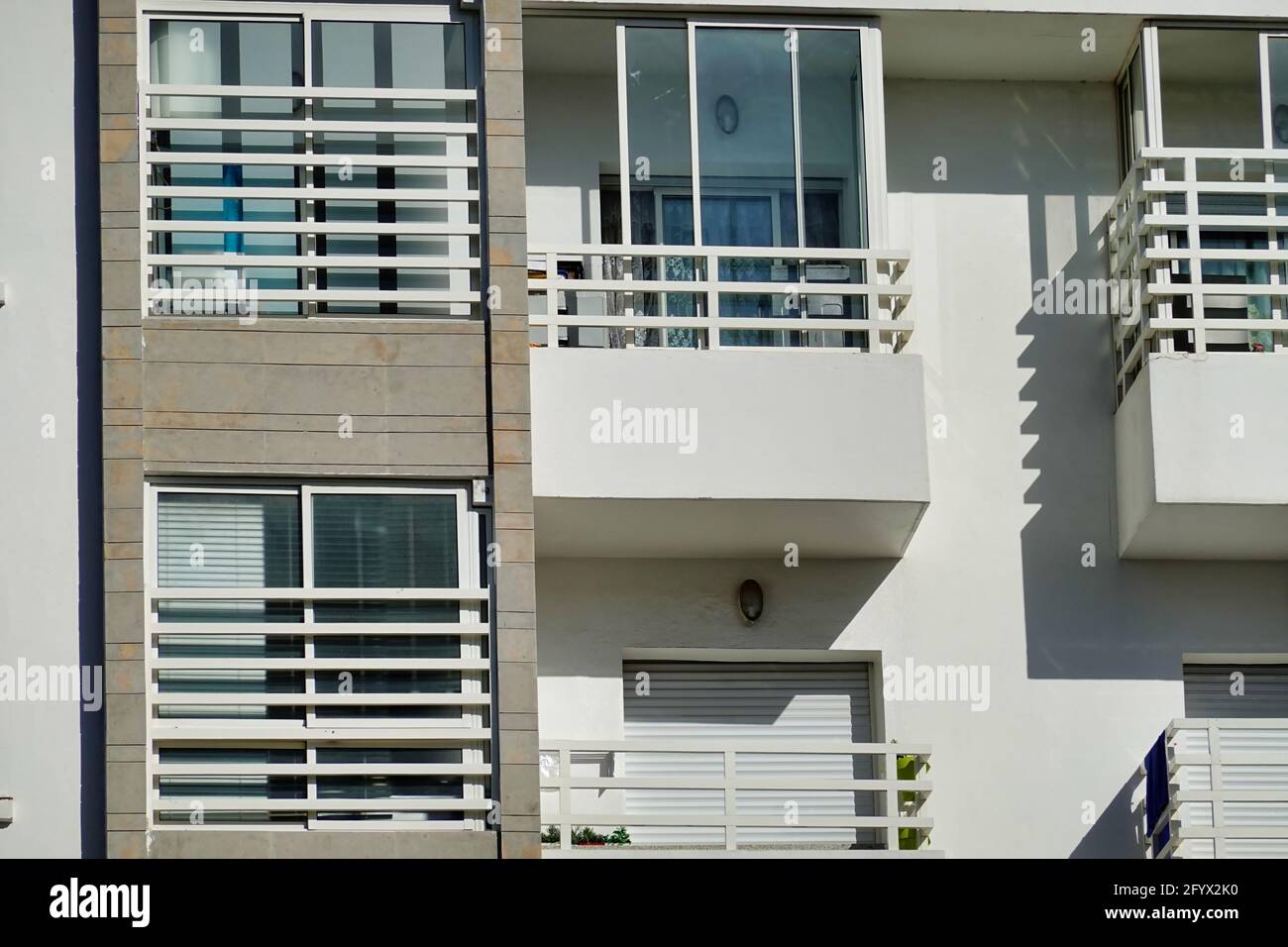 a white building with balconies and shuttered windows Stock Photo - Alamy