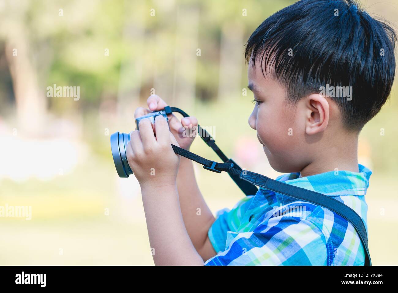 Handsome asian boy taking photo by vintage film camera on blurred ...