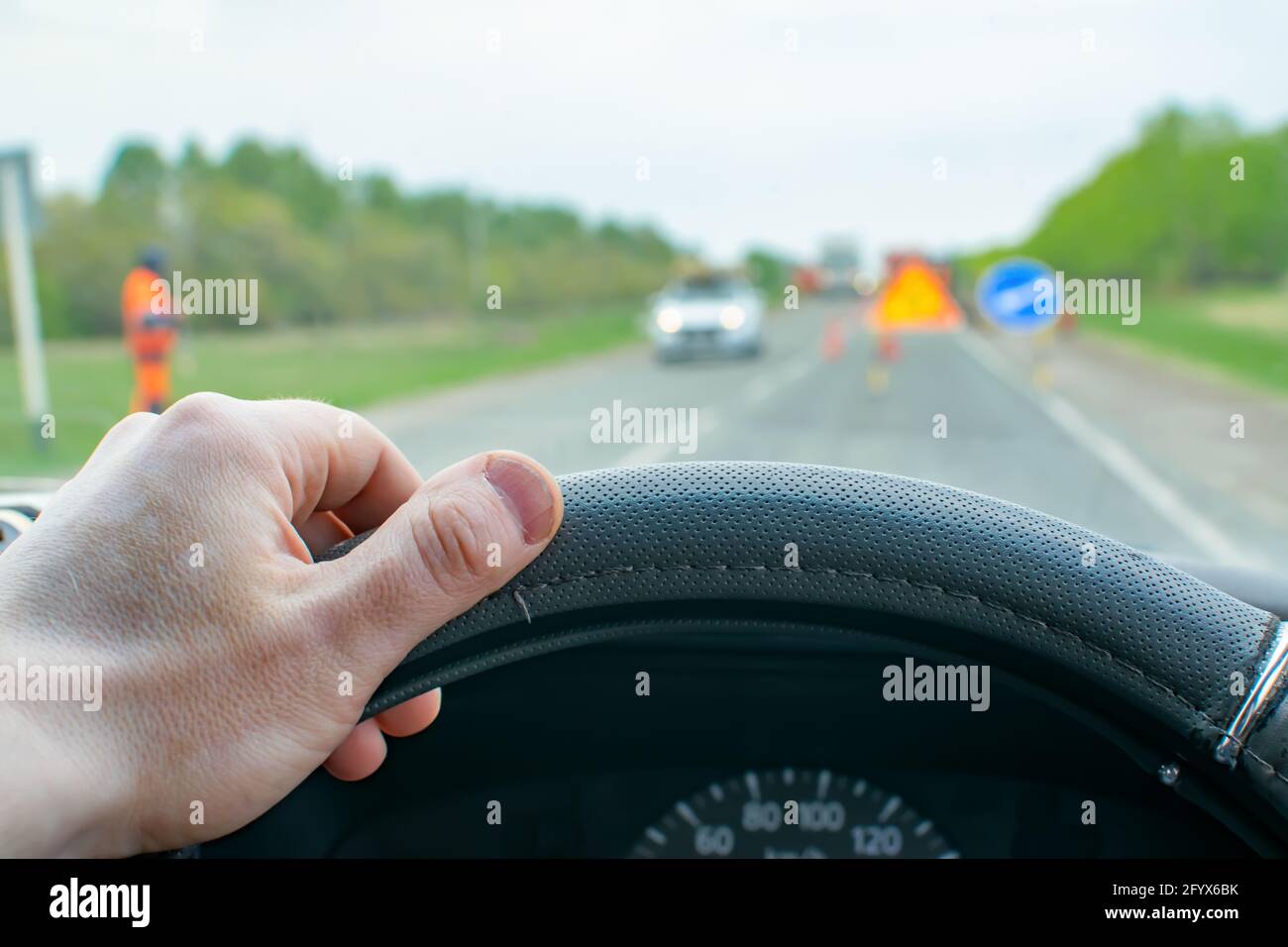 driver hand on the steering wheel inside the car on the background of ...
