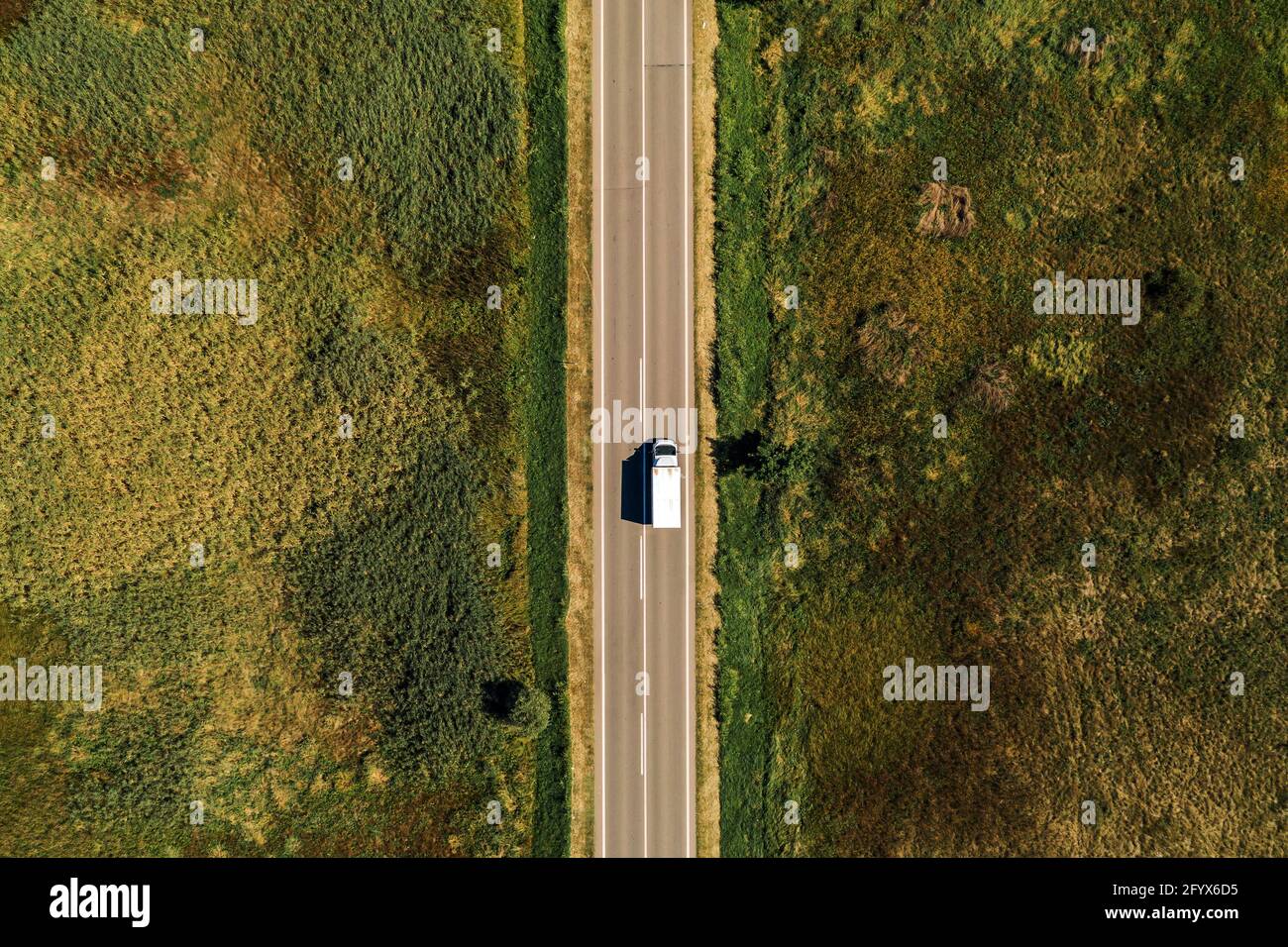 Aerial view of lorry truck on the road through countryside in sunny ...