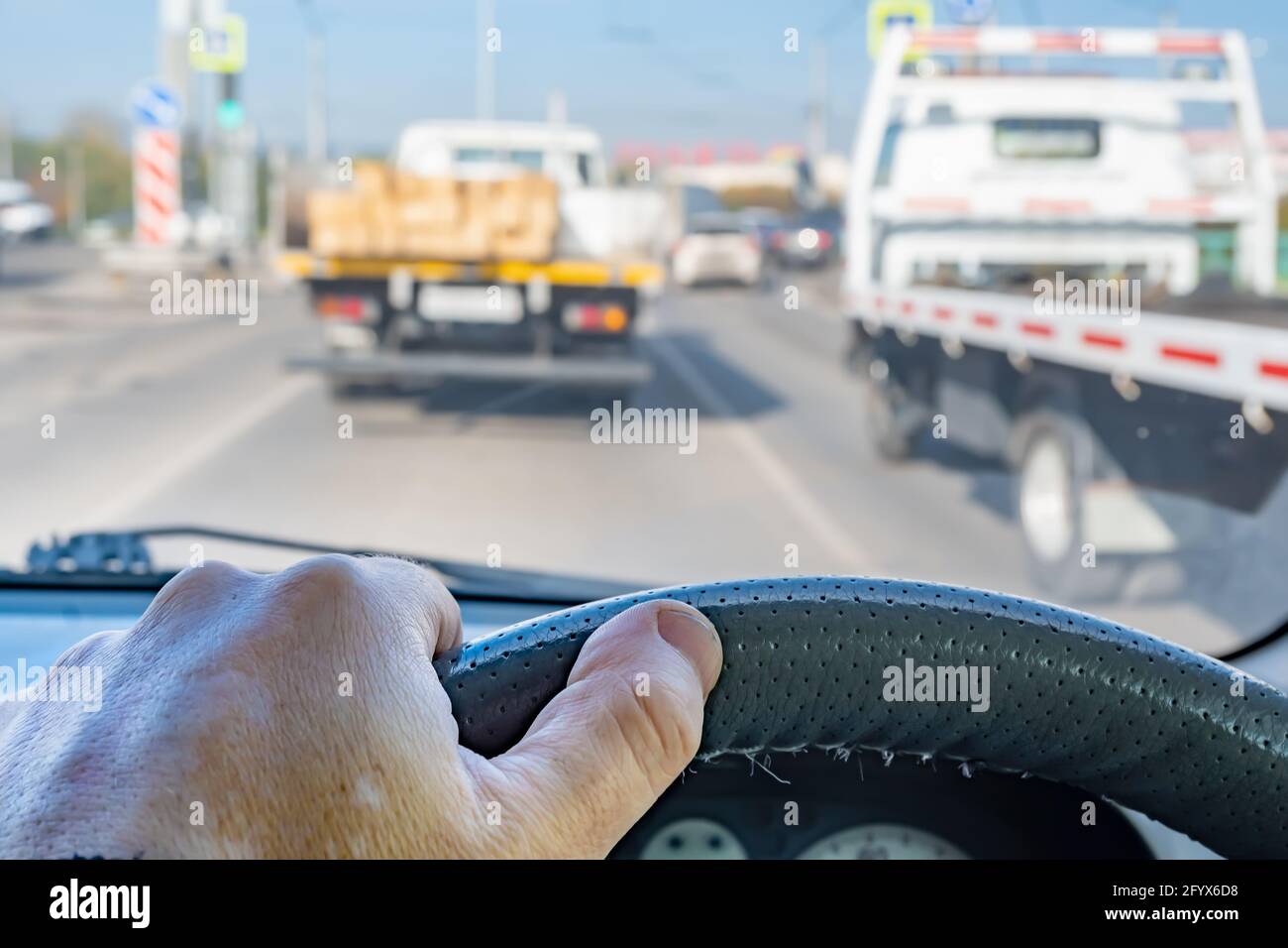 driver hand on the steering wheel inside the car during a traffic jam ...