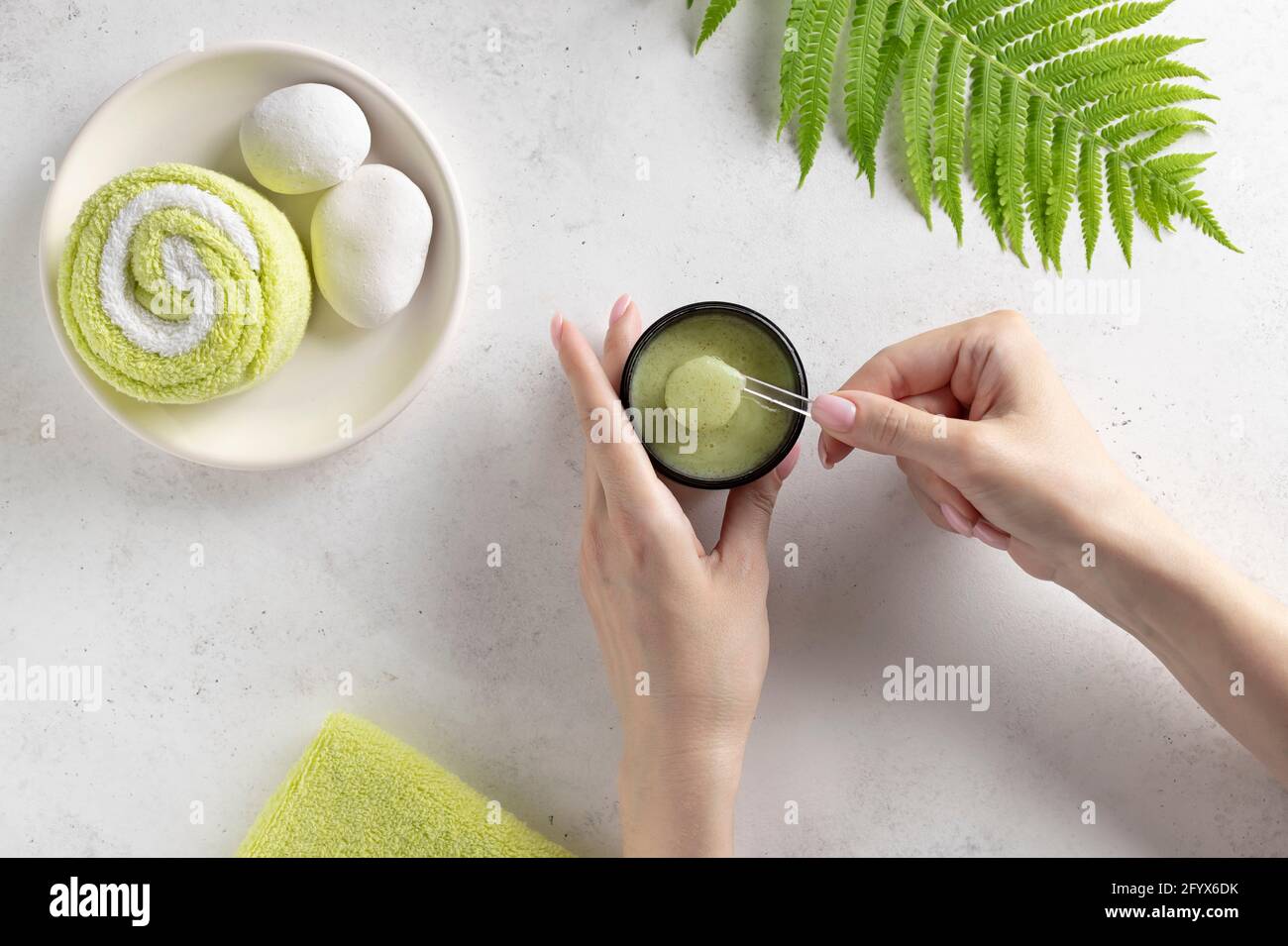female hands holding an open jar and a spoon with a scrub. Daily ...