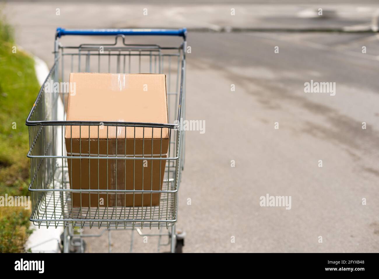 Shopping cart with carton box, a box in trolley Stock Photo - Alamy