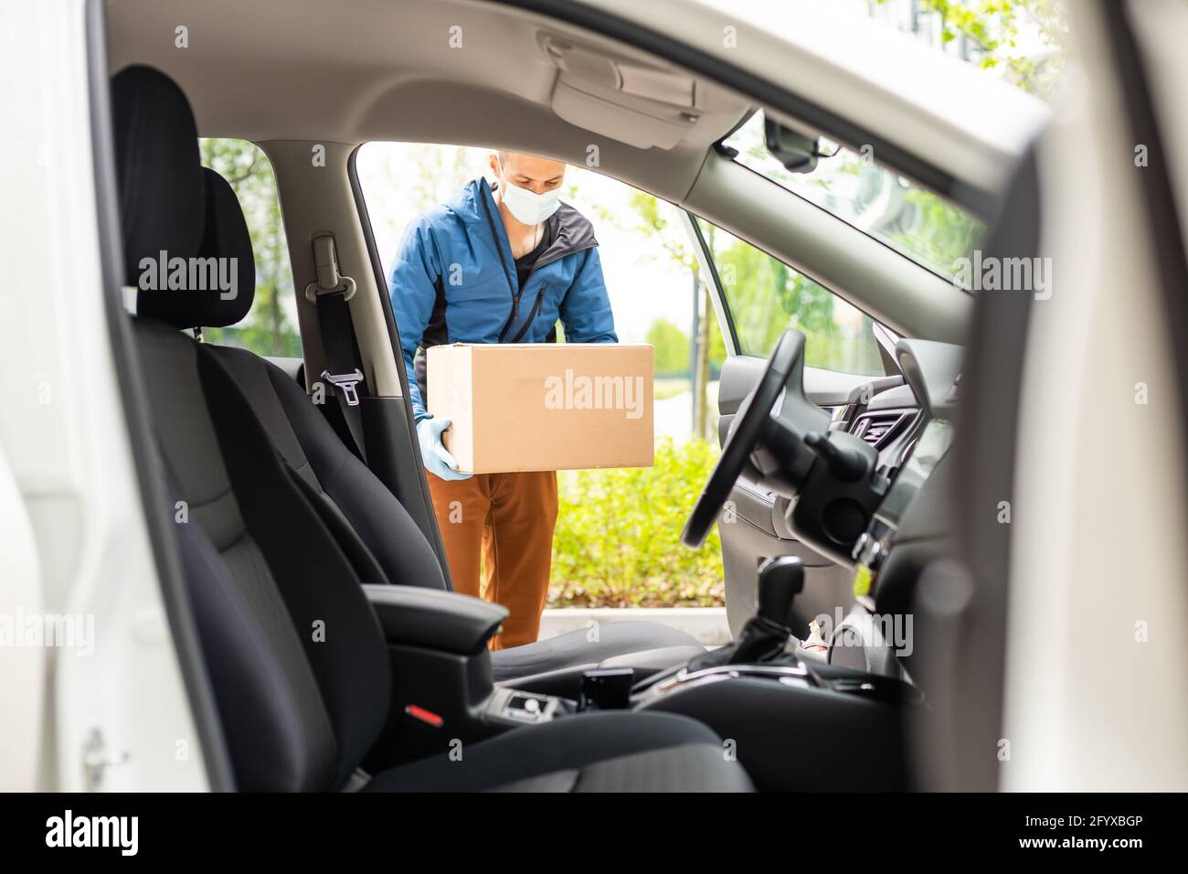 Delivery driver driving with parcels on seat Stock Photo - Alamy