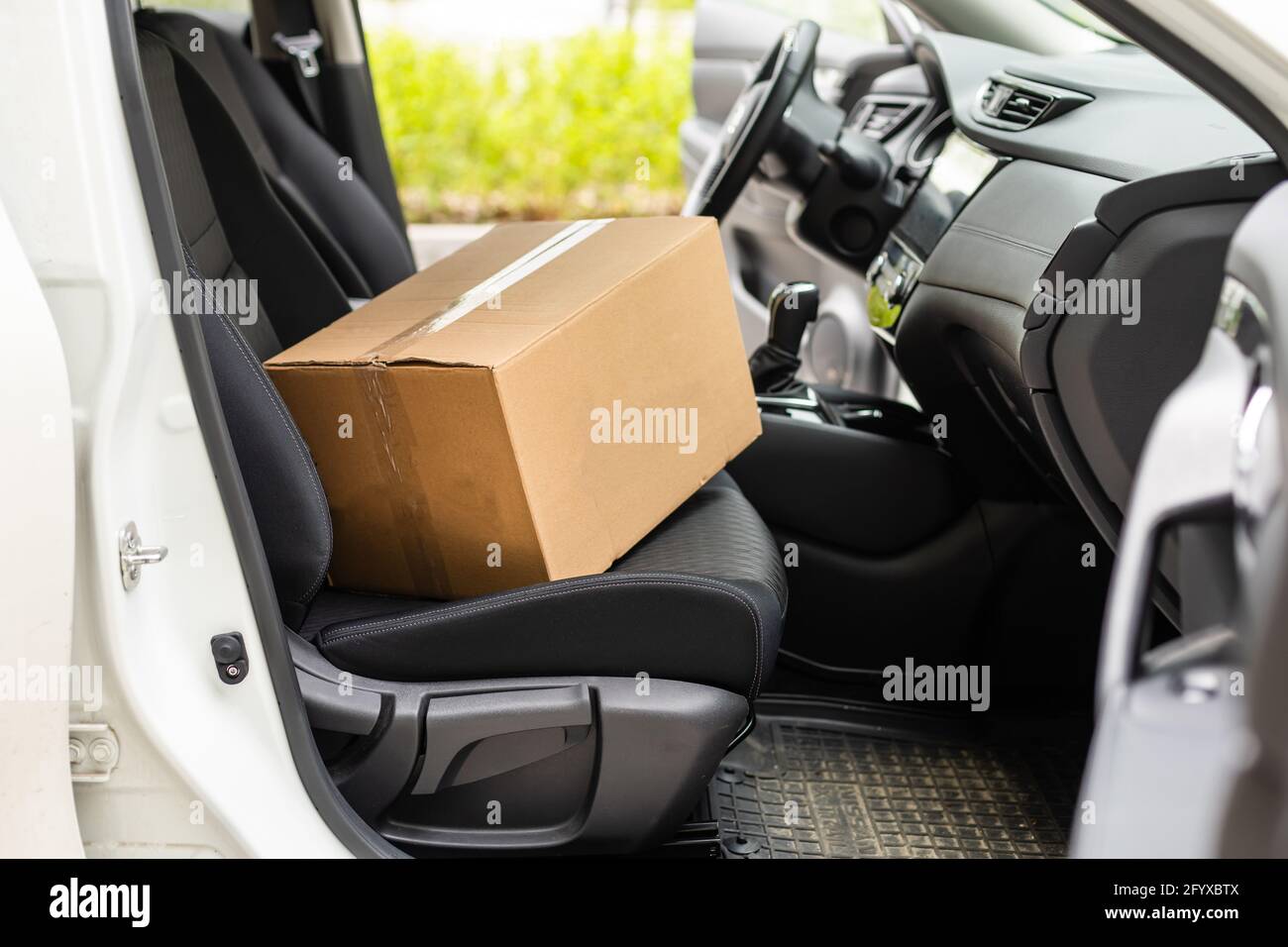 Delivery driver driving with parcels on seat Stock Photo - Alamy