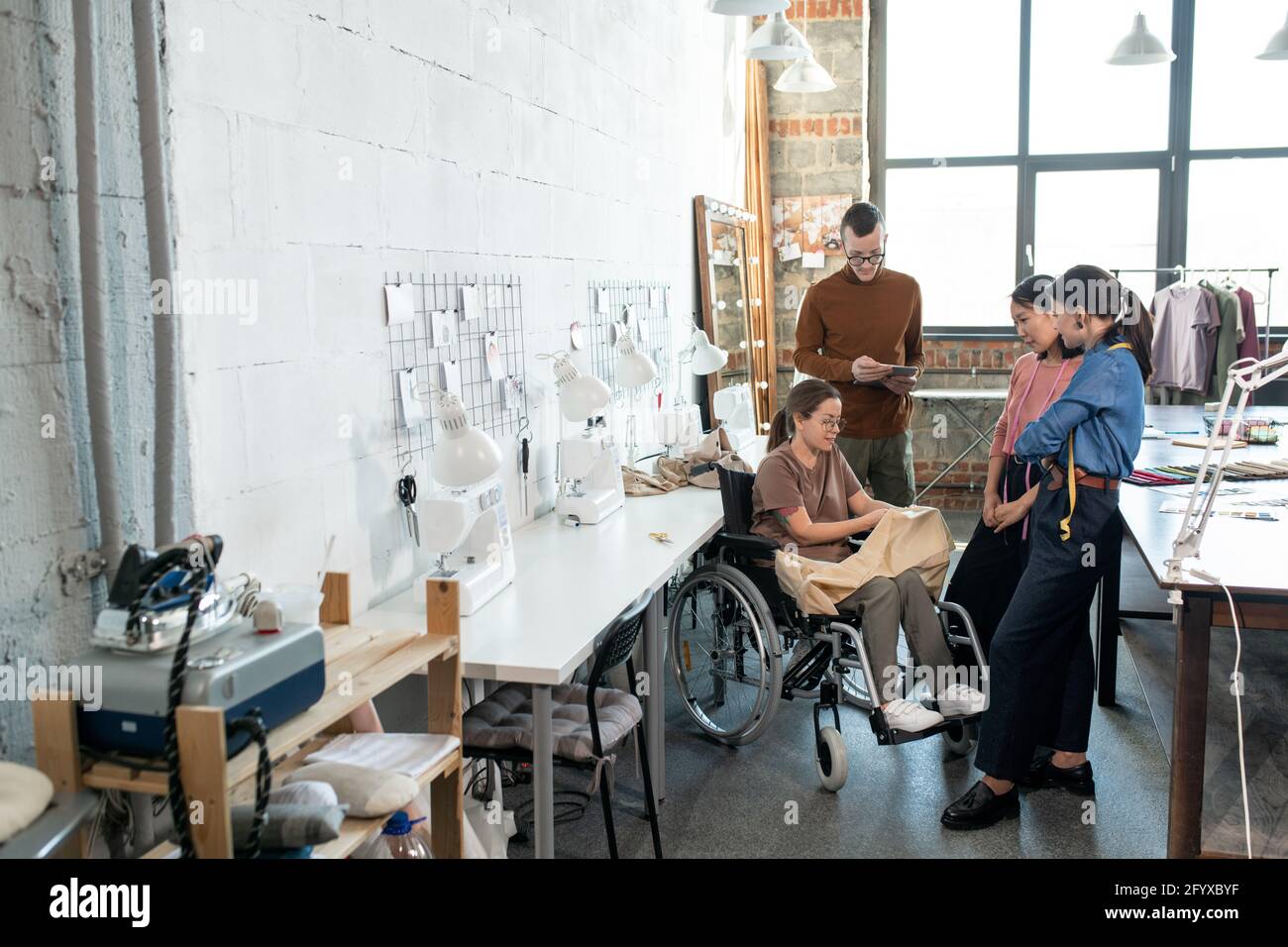 Group of tailors consulting during work over new fashion collection ...