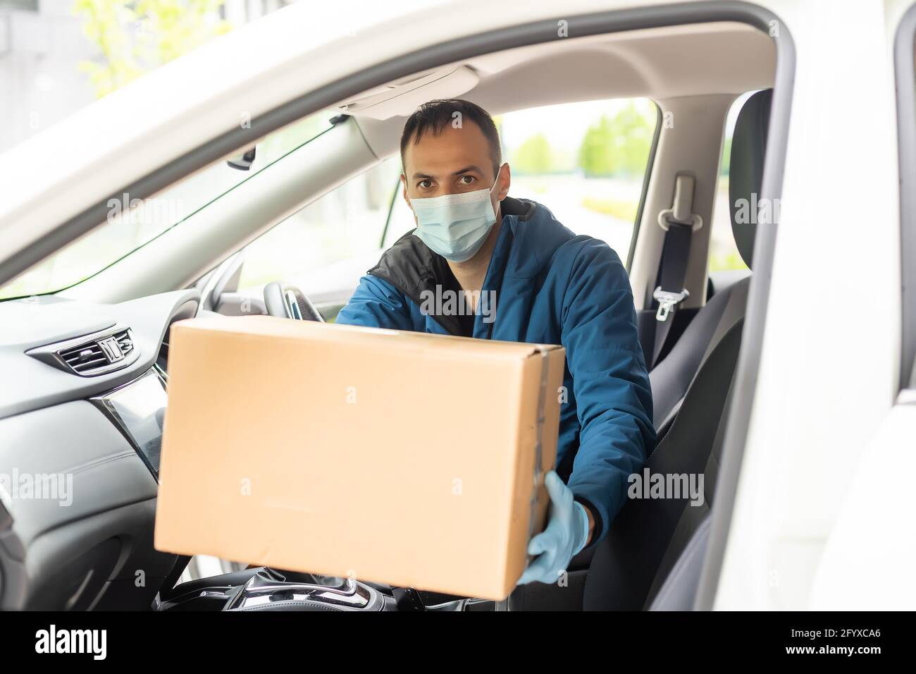 Delivery driver driving with parcels on seat Stock Photo - Alamy