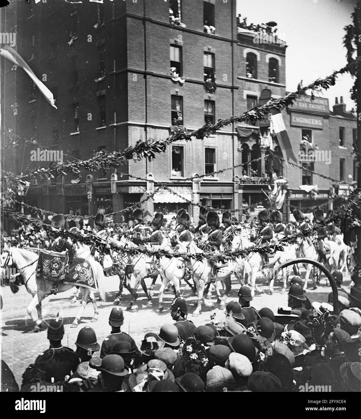 Onlookers watch as soldiers on horseback parade down the street during ...