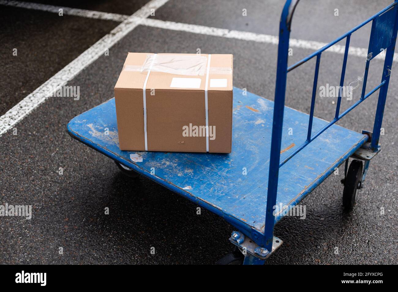 Shopping cart with carton box, a box in trolley Stock Photo - Alamy