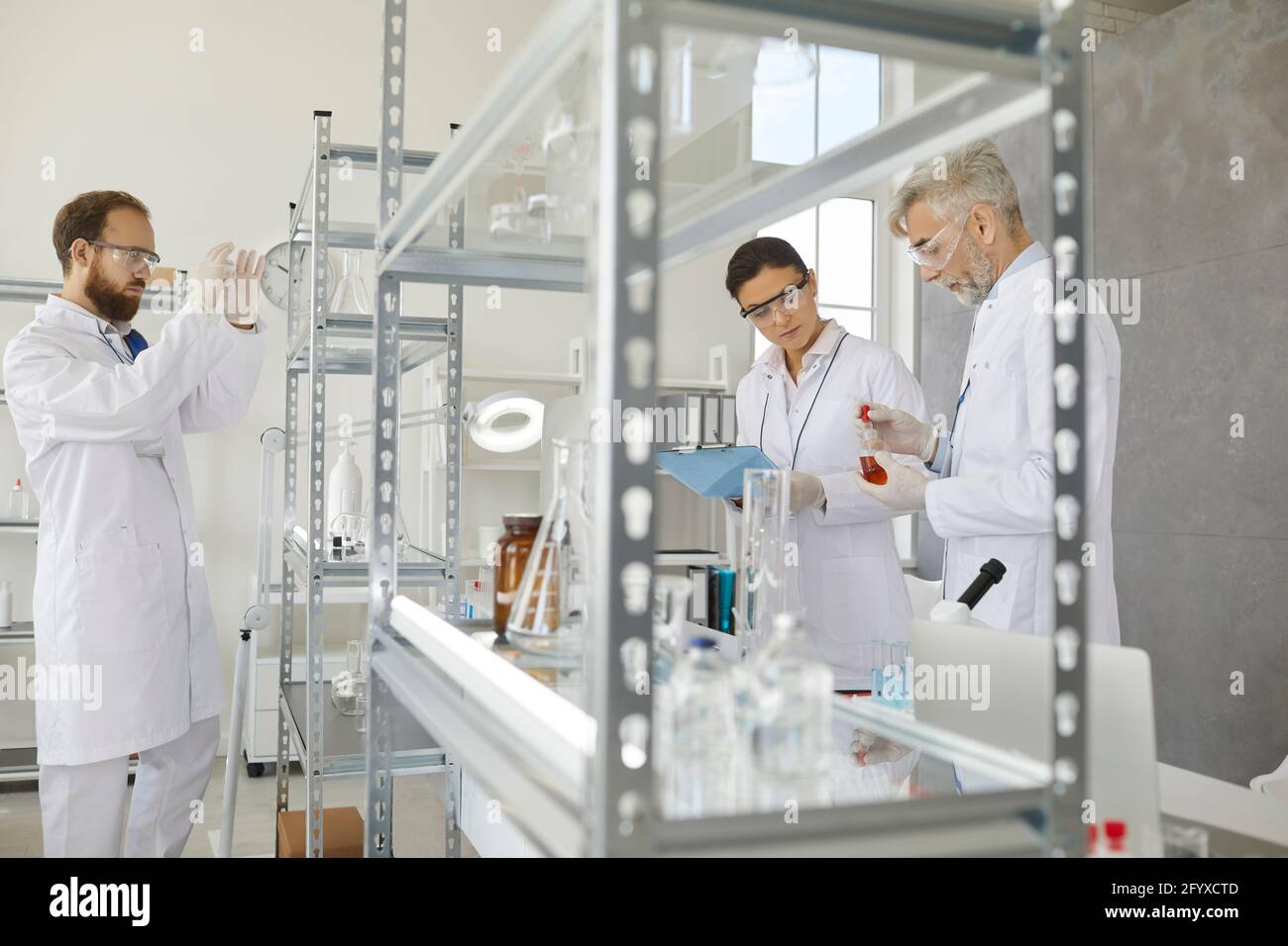 Group of scientists analyzing test sample conducting chemical ...