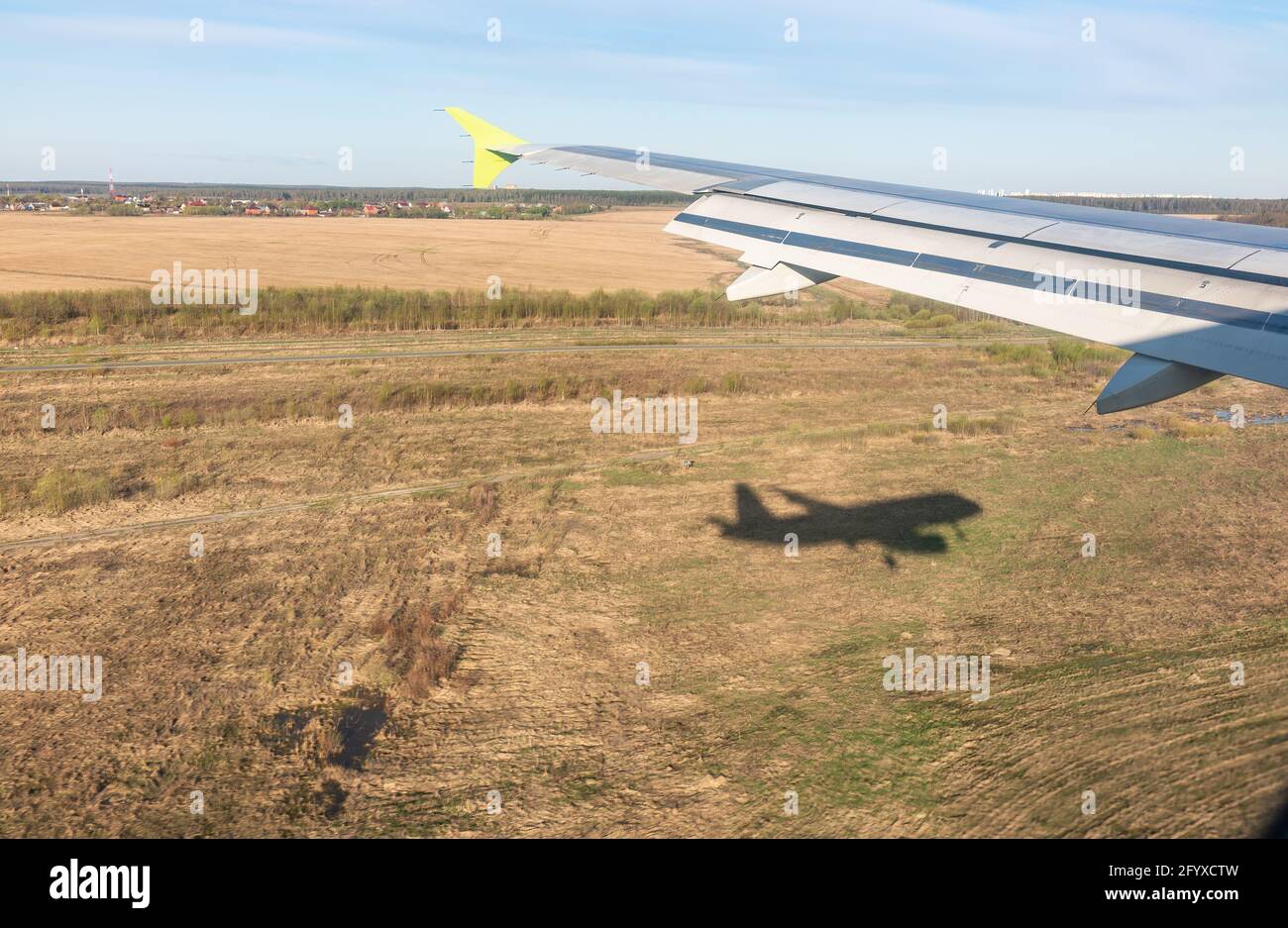View of airplane wing, Shadow of the plane on the ground during landing ...