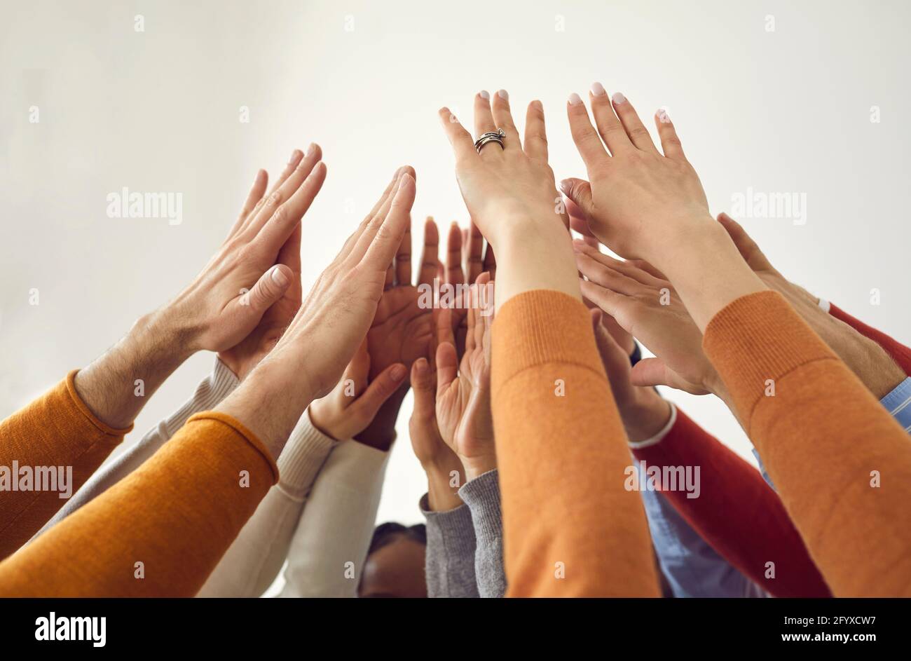 People holding hands up joining together show teamwork force closeup ...