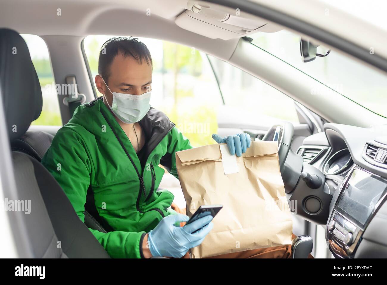 Delivery driver driving with parcels on seat Stock Photo - Alamy