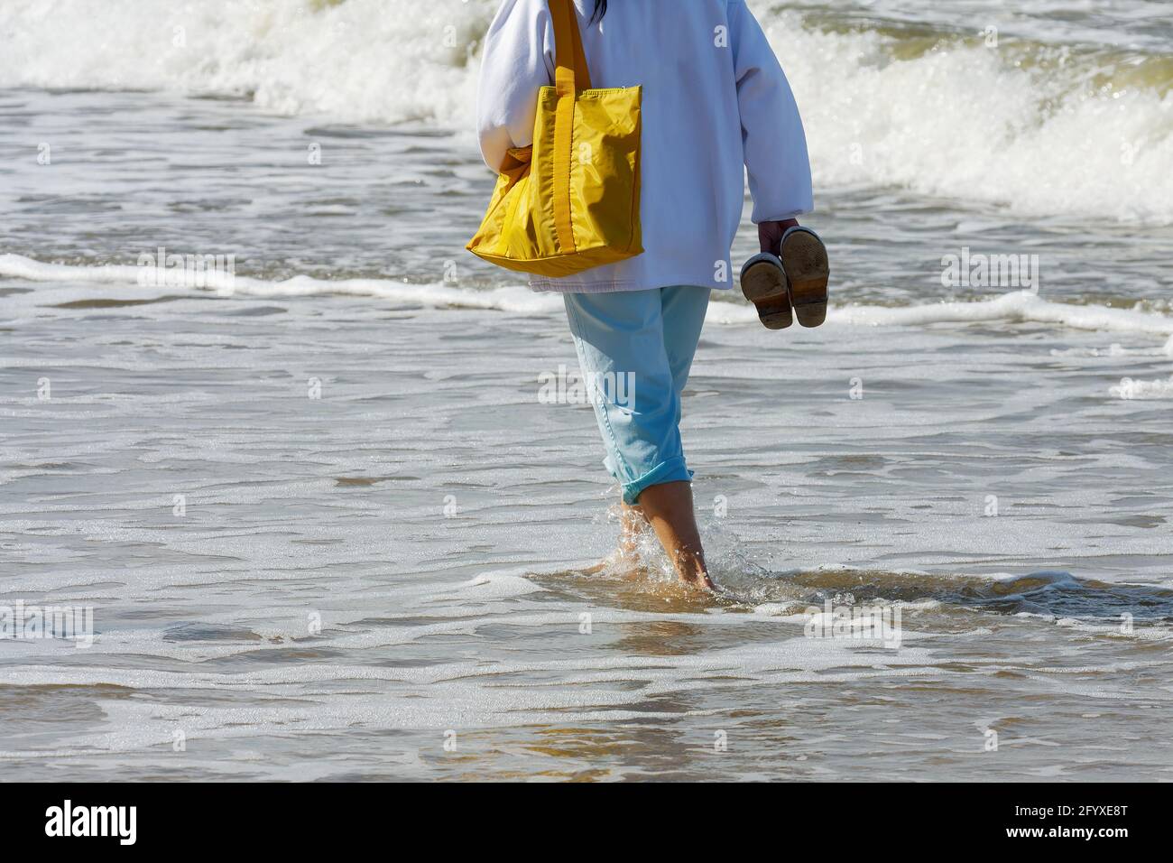 Rear view shot of a relaxed woman walking along a beach Stock Photo - Alamy
