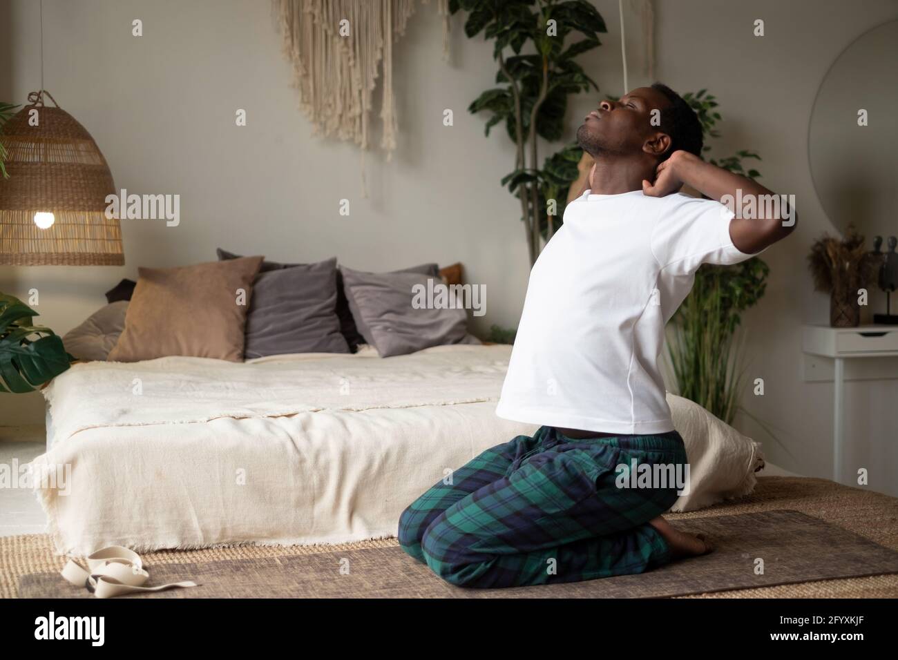 Young african man making asana exercises for shoulders stretching Stock ...
