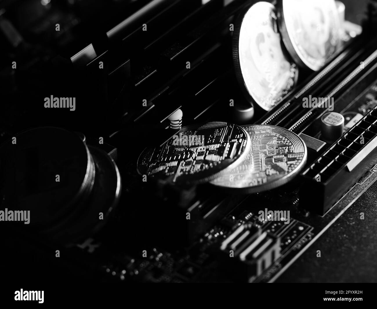 A grayscale of cryptocurrency coins lit in the darkness Stock Photo - Alamy