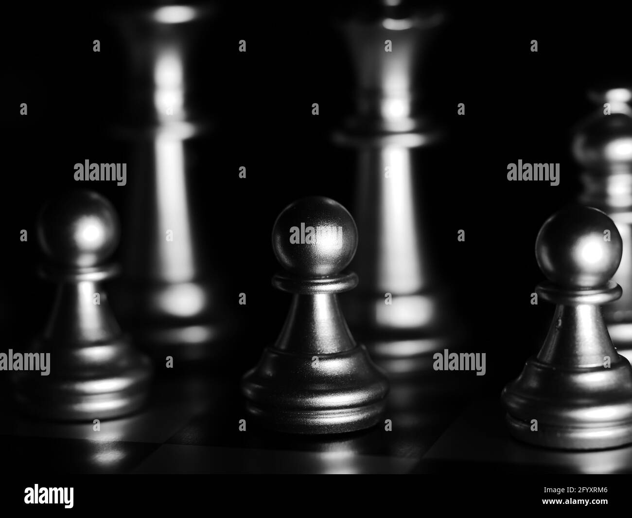 A dramatic grayscale shot of chess figures lit in the darkness Stock ...