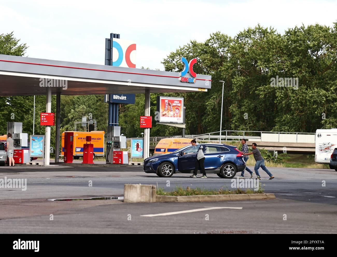 Some people shooting at a car outside a gas station Stock Photo - Alamy