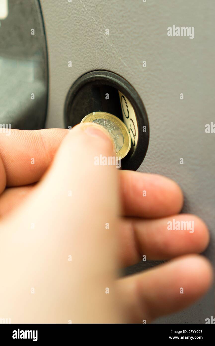 A vertical shot of a person putting a coin into a machine Stock Photo ...