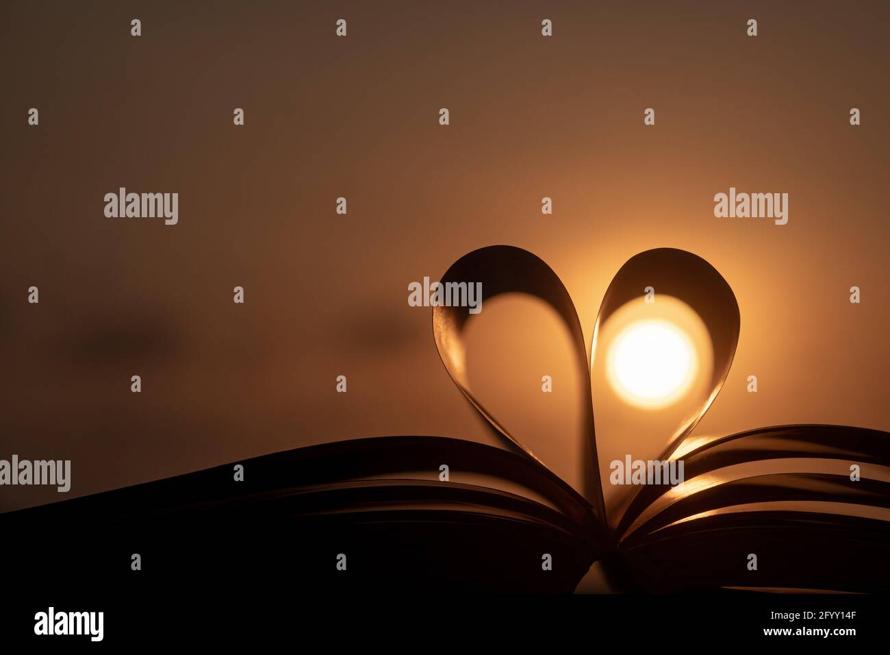 An open book with heart-shaped pages against a beautiful sunset Stock ...