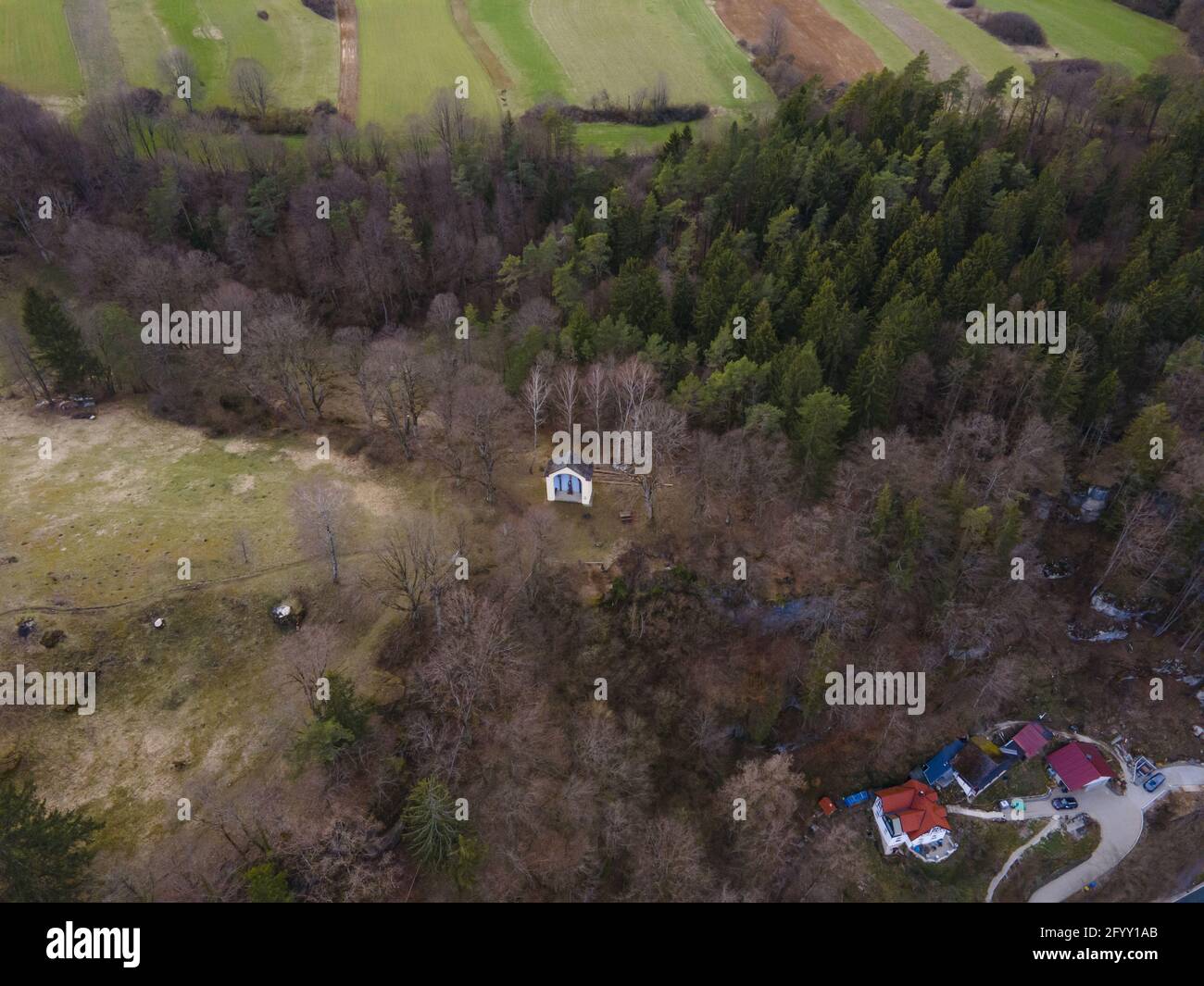 A bird's-eye view at small wooden huts in the thick forest at autumn ...