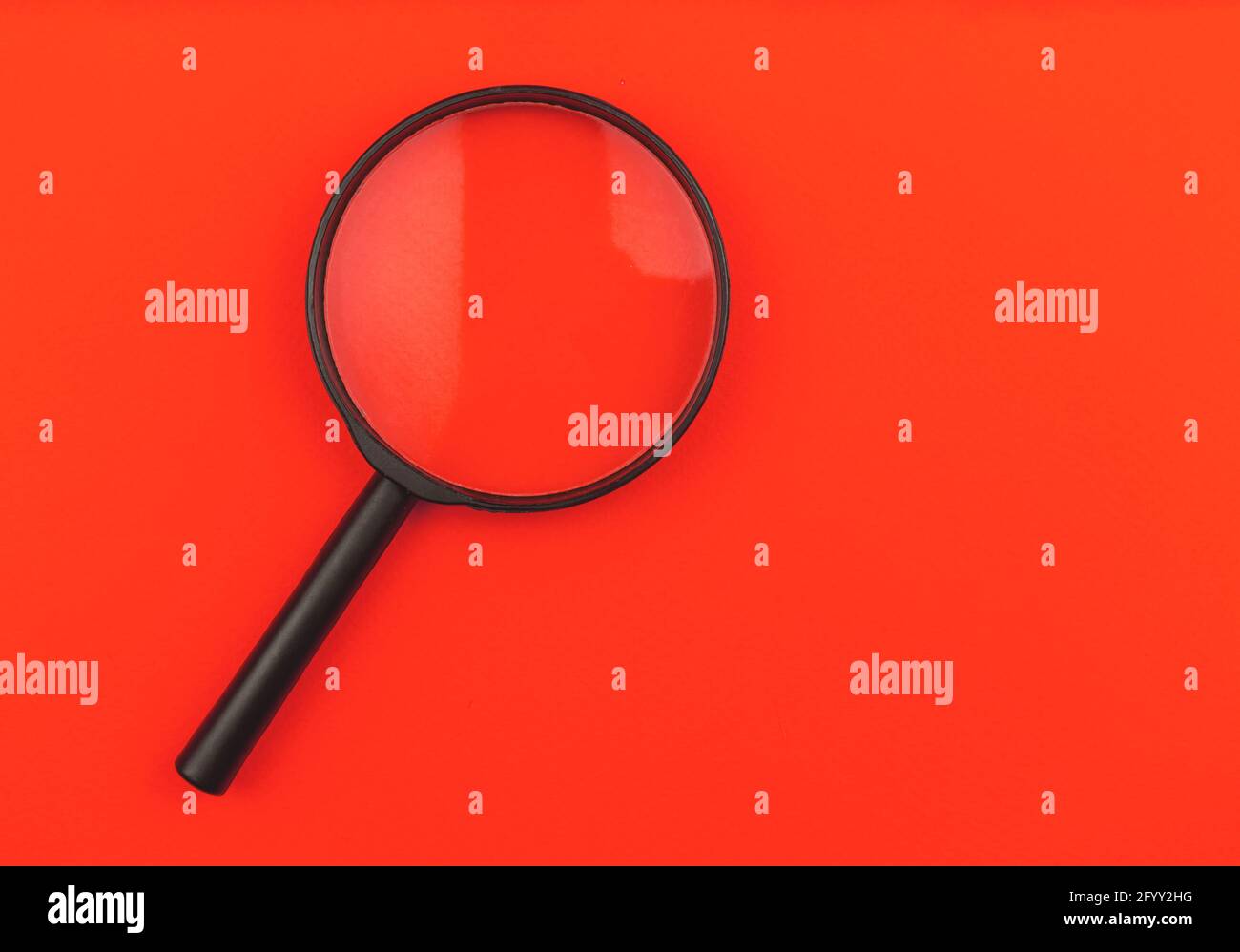 Magnifying glass on a red background isolated, top view Stock Photo - Alamy